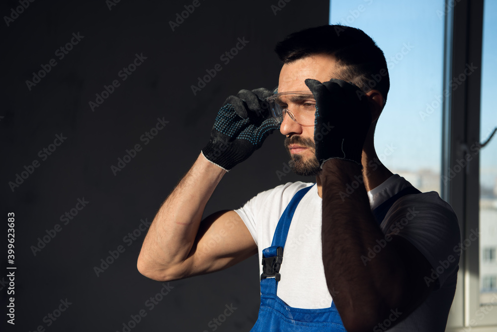 The worker is in a dark room. He puts on safety glasses Stock Photo ...