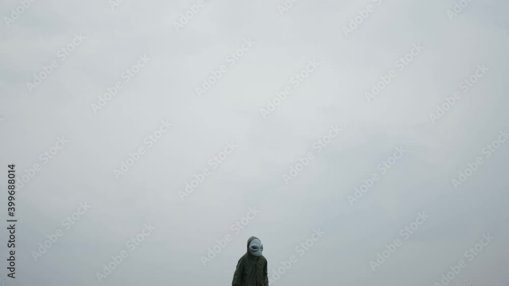 alien in green suit stands alone in the sky, looks back,alien arrived ...
