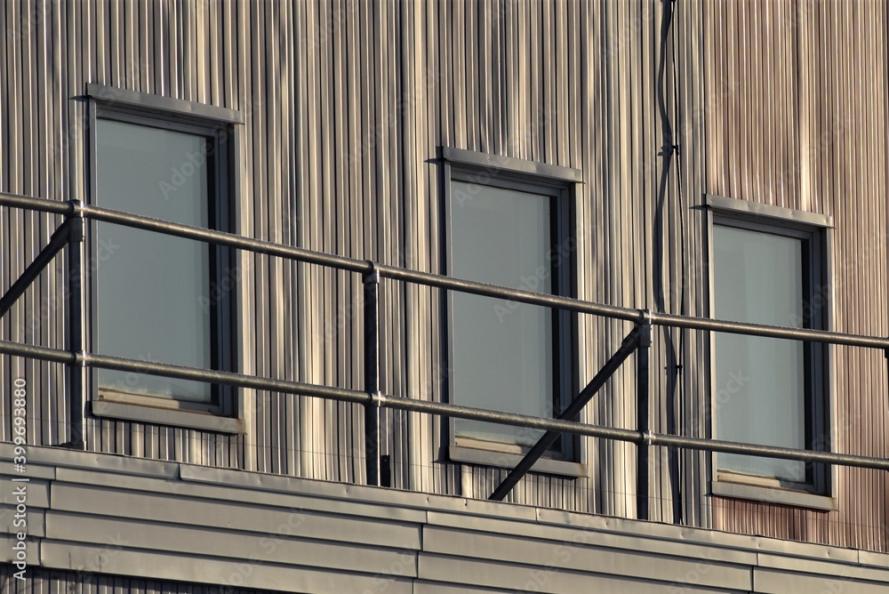 Exterior of metal sided building with windows and railings. Diagonal ...