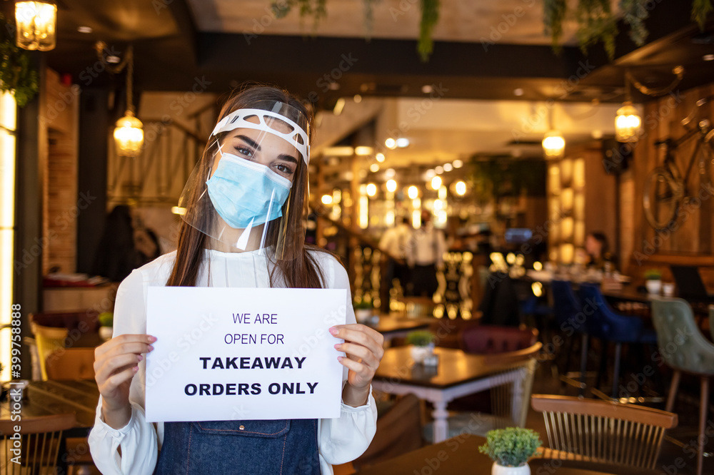 Female waitress hanging open sign while reopening restaurant for ...