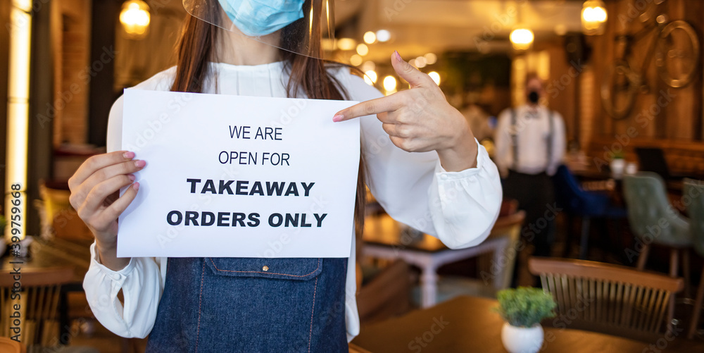 Female waitress hanging open sign while reopening restaurant for ...
