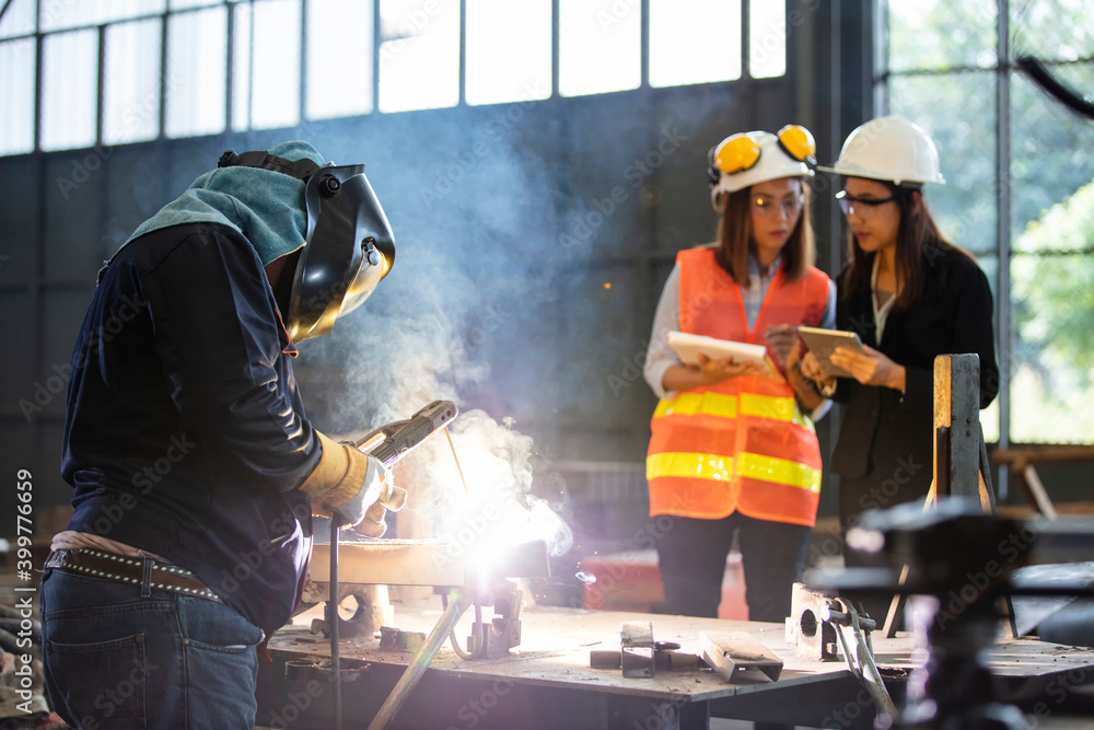 Two Business women discussing an working front welding production ...