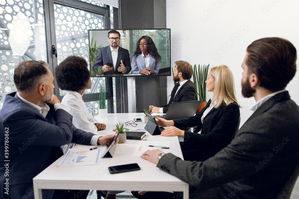 Focused multiracial business people in conference room, looking at a ...