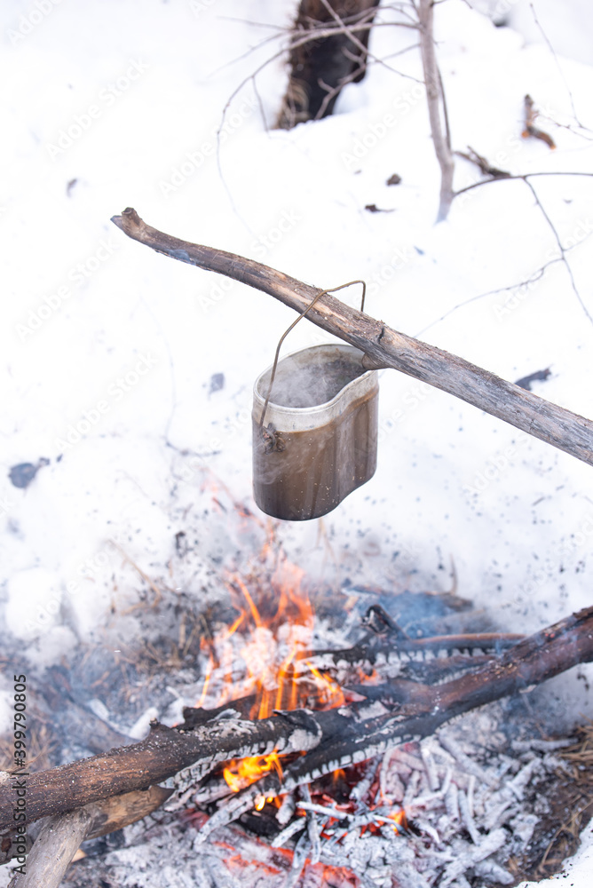 Pot over a fire during a winter hike. Stock Photo | Adobe Stock