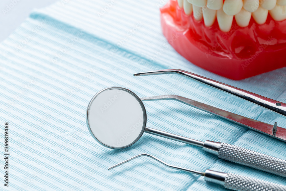 Different dental instruments and model of a mouth on a blue dental ...