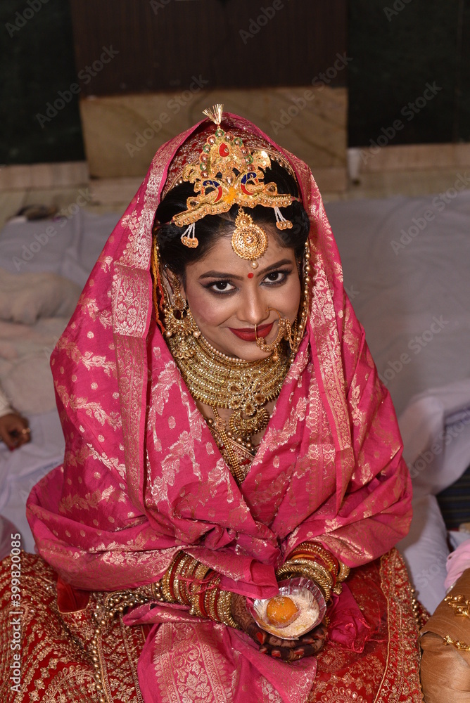 Cute Indian Bride laughing during her wedding ceremony. She is wearing ...