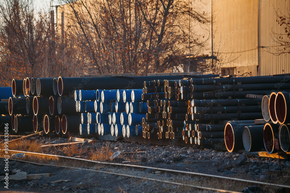 Stack of cast iron pipes in loading area waiting for transportation ...