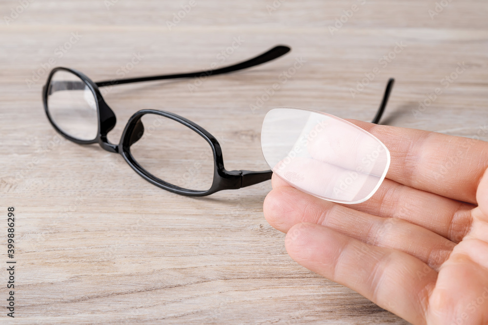 Hand shows the lens fell out of the eyeglasses because of the broken ...