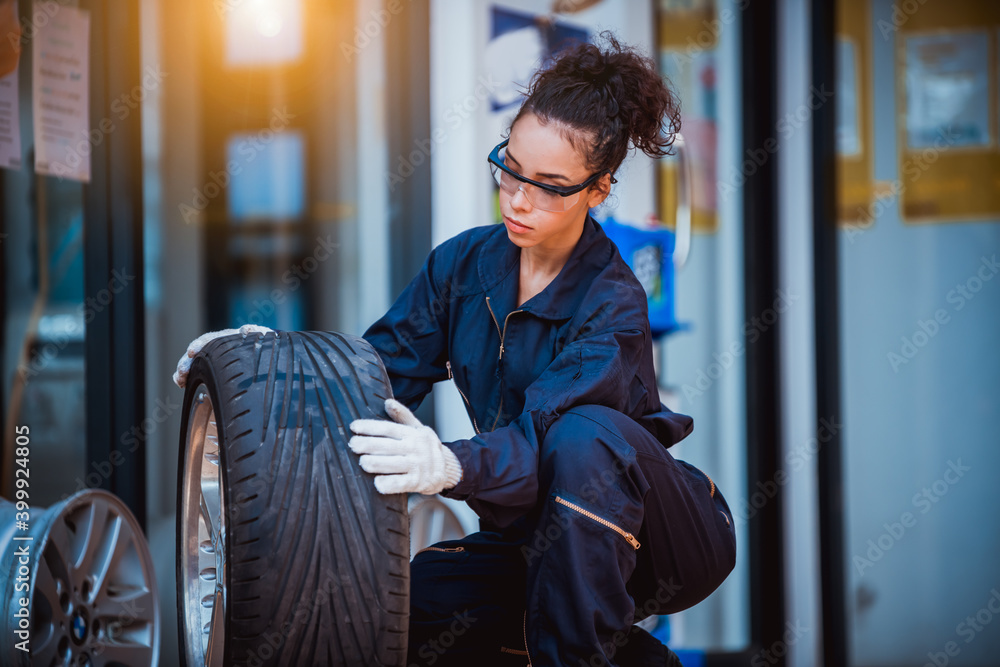 Foto de Car mechanic under checking car wheels at garage for ...