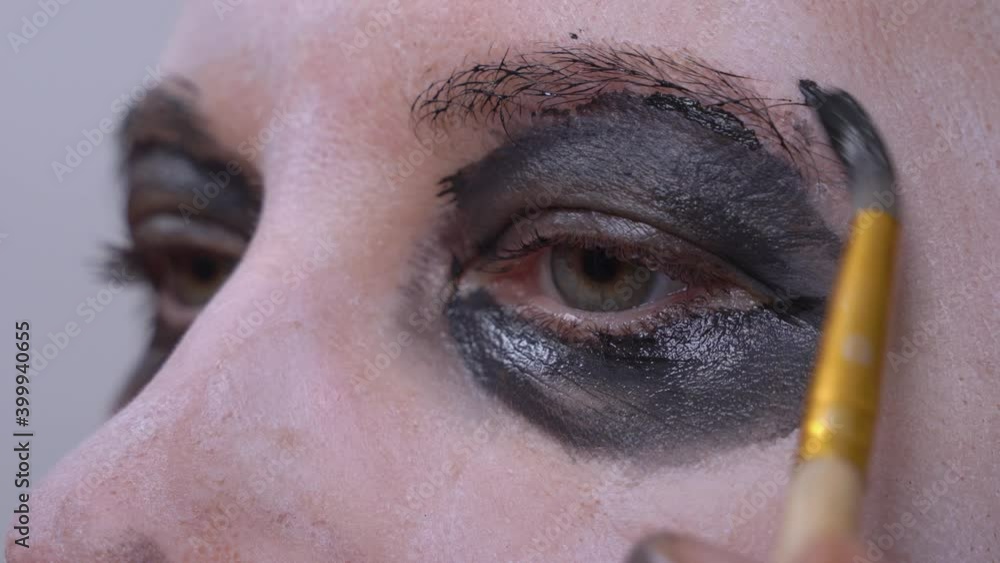 Professional makeup artist applies unusual black makeup to eyes of ...
