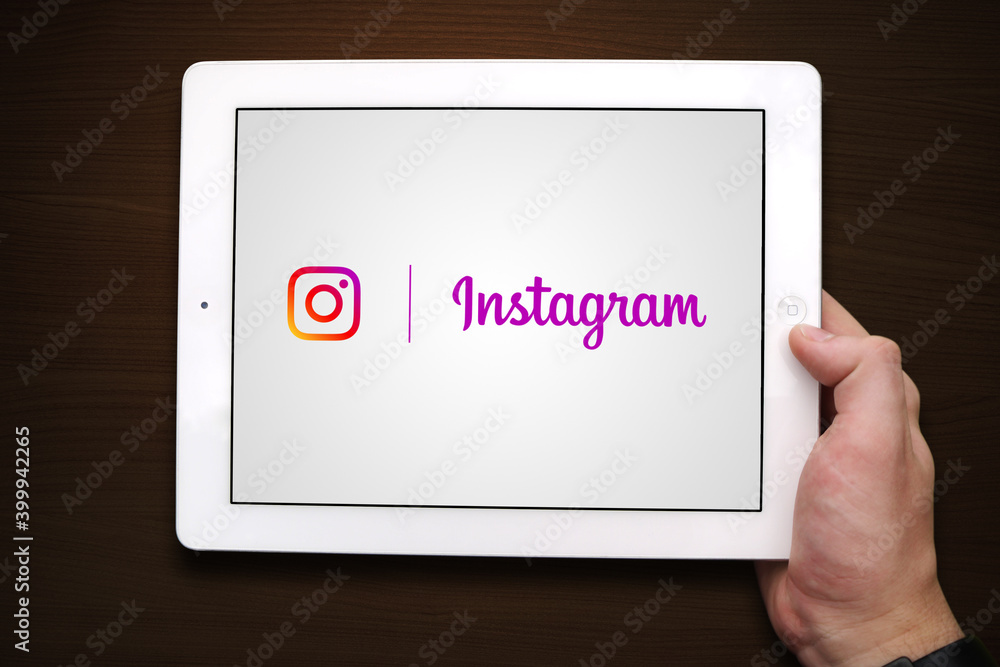A hand holding an iPad/tablet with Instagram logo displayed in full ...