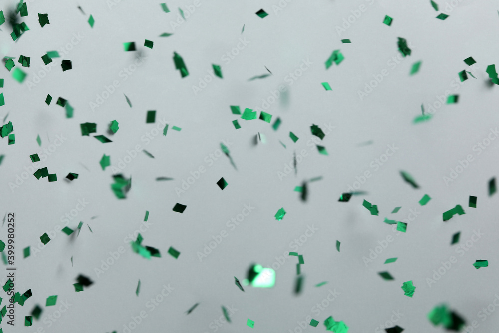 Shiny green confetti falling down on light grey background Stock Photo ...