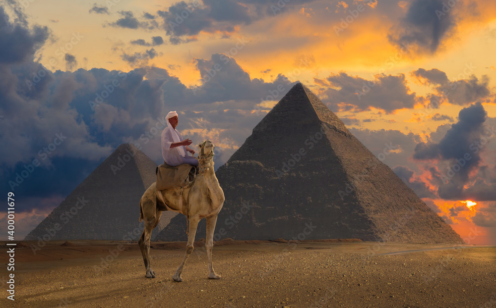 A dramatic morning sky over Giszeh in Upper Egypt. An Egyptian in blue ...