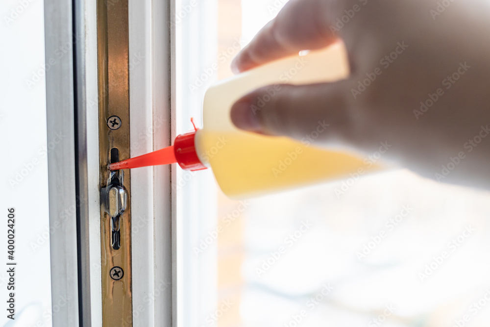 lubricating window frame mechanism with oil from oiler close up Stock ...