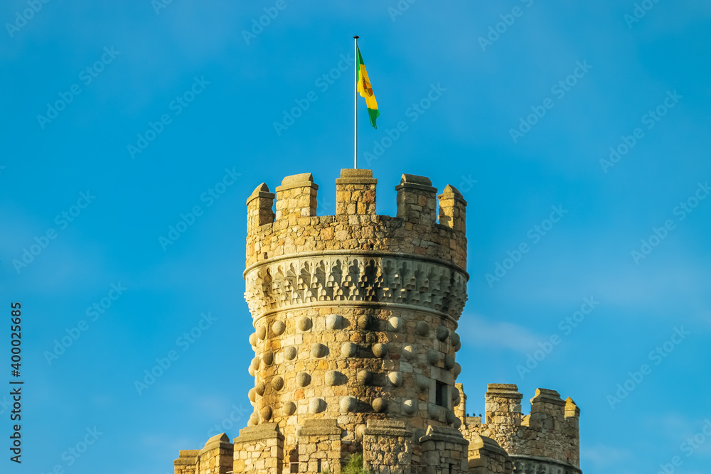 Medieval castle on the mountain, tower with flag, blue sky and clouds ...