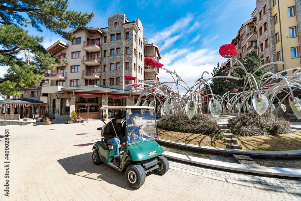 BANSKO, BULGARIA - circa MARCH, 2017: Golf players use golf-cart for ...