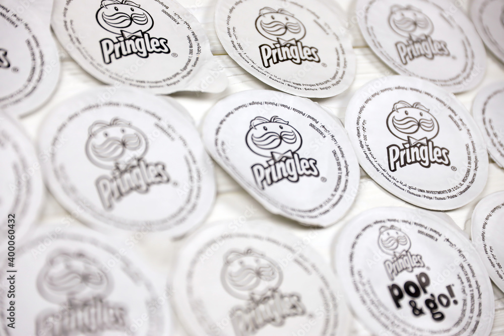 Pringles logo on paper membranes on white wooden table. Pringles is a ...