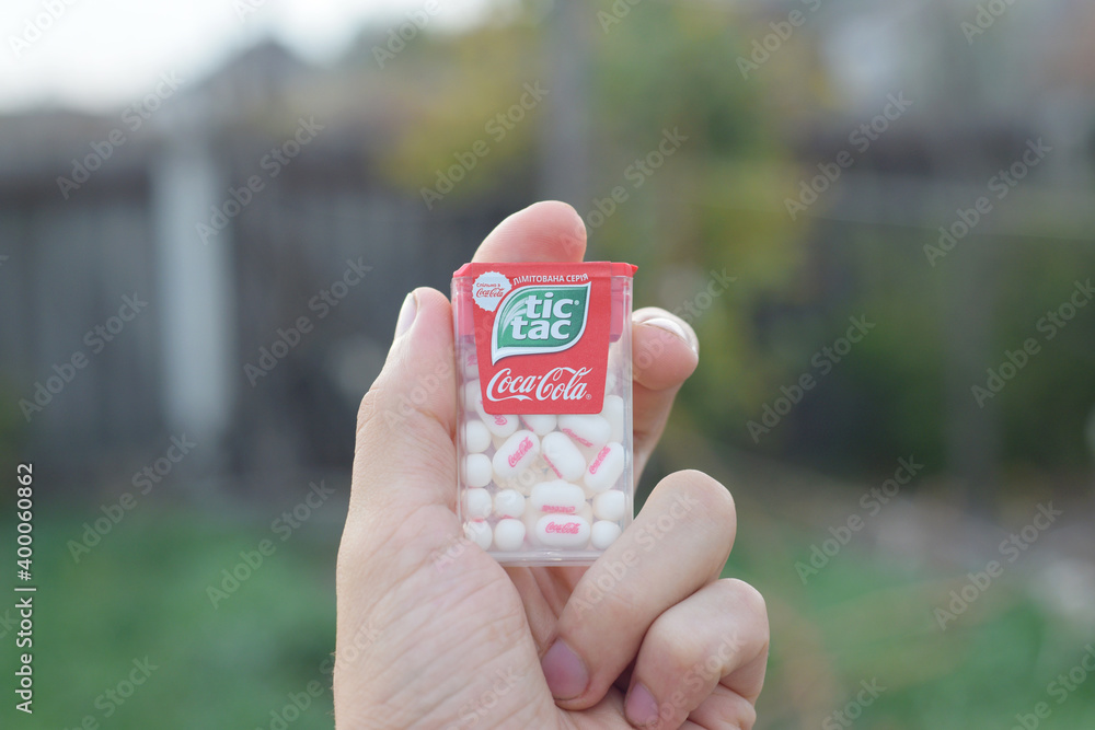 Tic Tac Candy package with Coca-Cola taste in male hand. Tic tac is ...