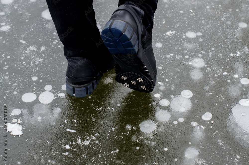 Female legs in black boots with Ice Grippers Cleats for Shoes and Boots ...