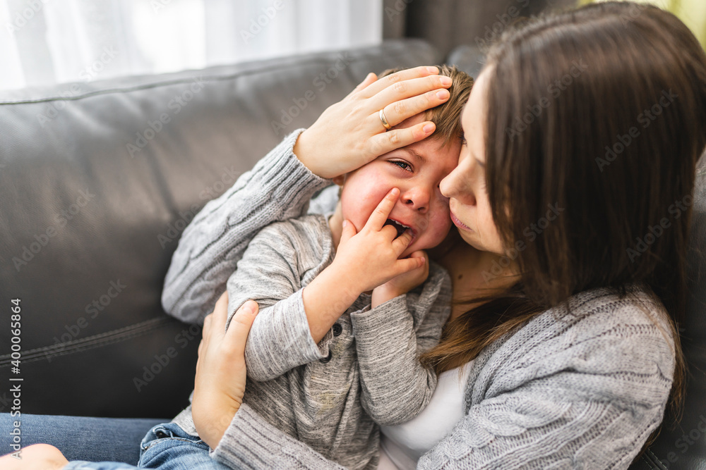 Devoted mother hugging and comforting her son on sofa Stock Photo ...