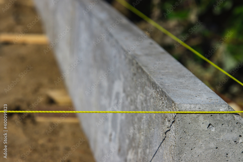new concrete blocks and curbs for road construction in the sand with a ...