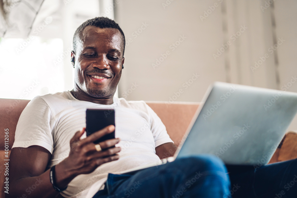 Young black african man relaxing using laptop computer working and ...