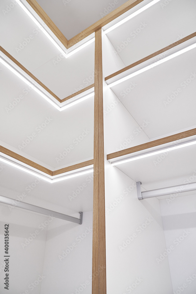 Elegant white shelving with LED lighting. Shelving of laminated boards ...