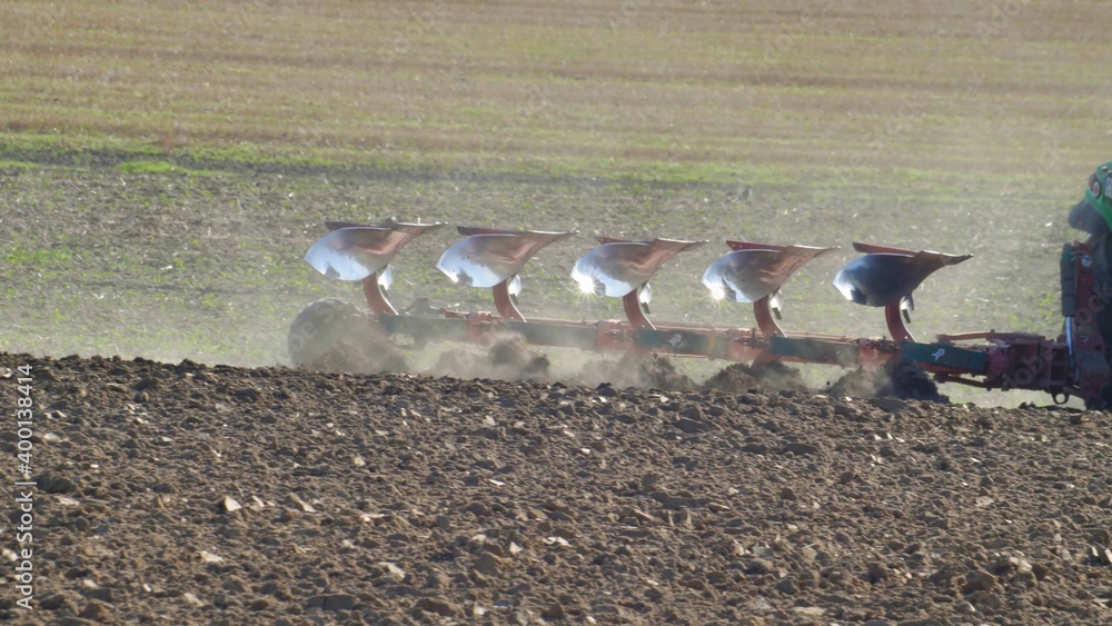 Foto de Farmer Ploughing Soil using Tractor with Mouldboard Plough on ...
