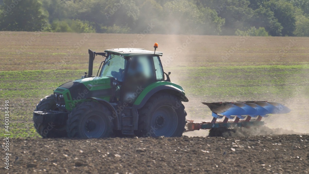 Farmer Ploughing Soil using Tractor with Mouldboard Plough on Sunny Day ...