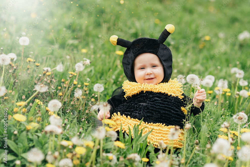 cute and cheerful portrait of little child sitting in blooming flowers ...