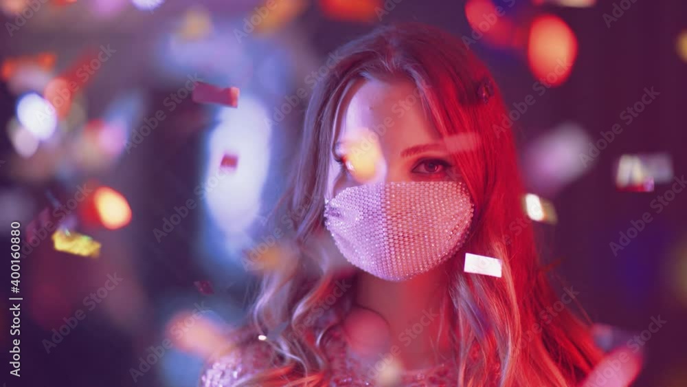 Party, beautiful female wearing protective mask in the night club ...
