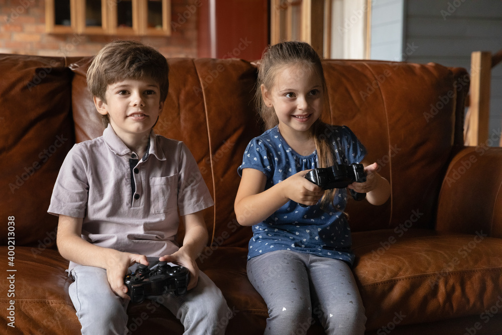 Little gamers. Excited kids children brother sister sit on cozy couch ...