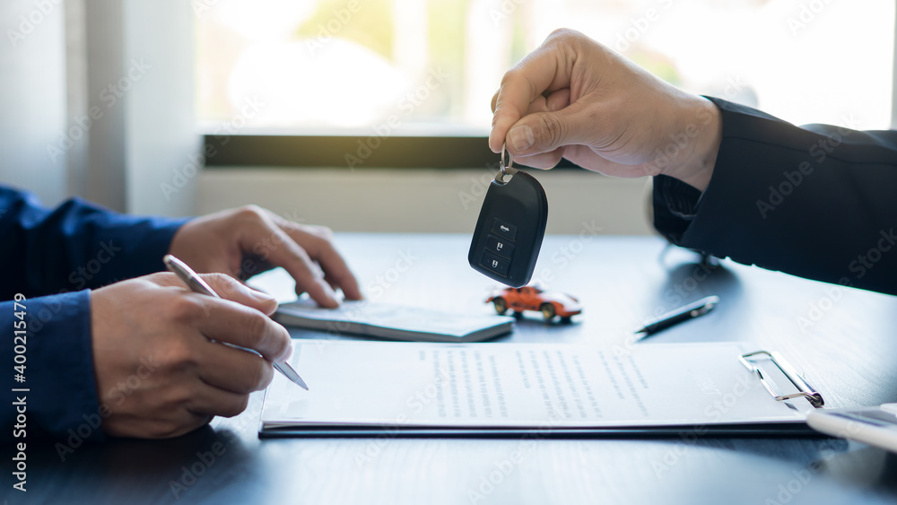 Hand holding car keys and car rental concept A close-up view of the ...