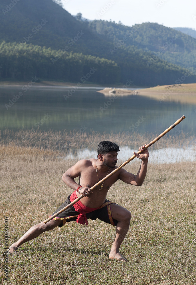 Indian fighter with bamboo stick performing Kalaripayattu Martial art ...