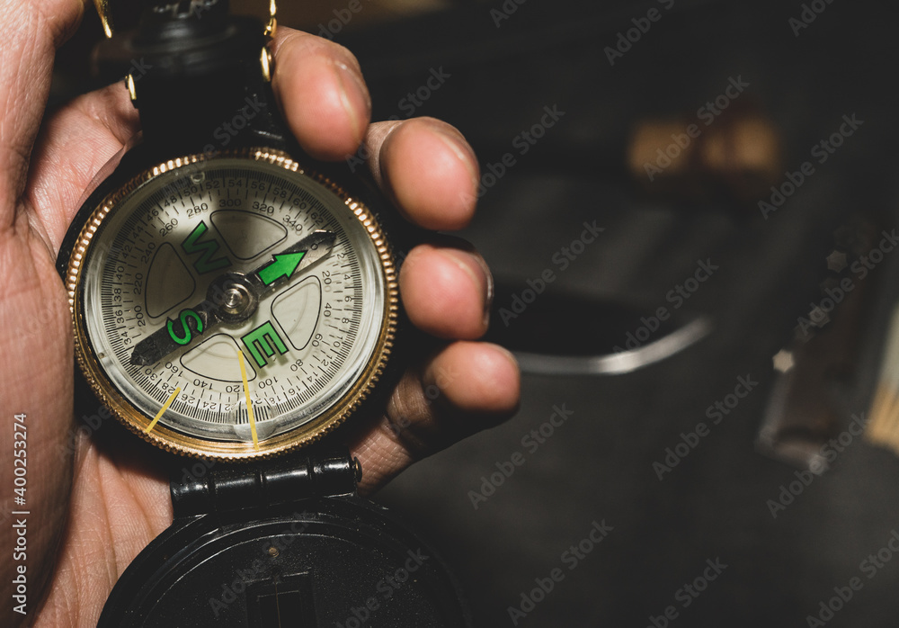 military compass in hand. Bushcrafters holding the compass in hand on ...