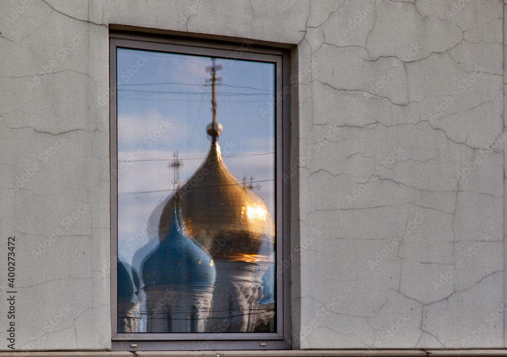Reflection of the domes of the temple in the window of a modern ...
