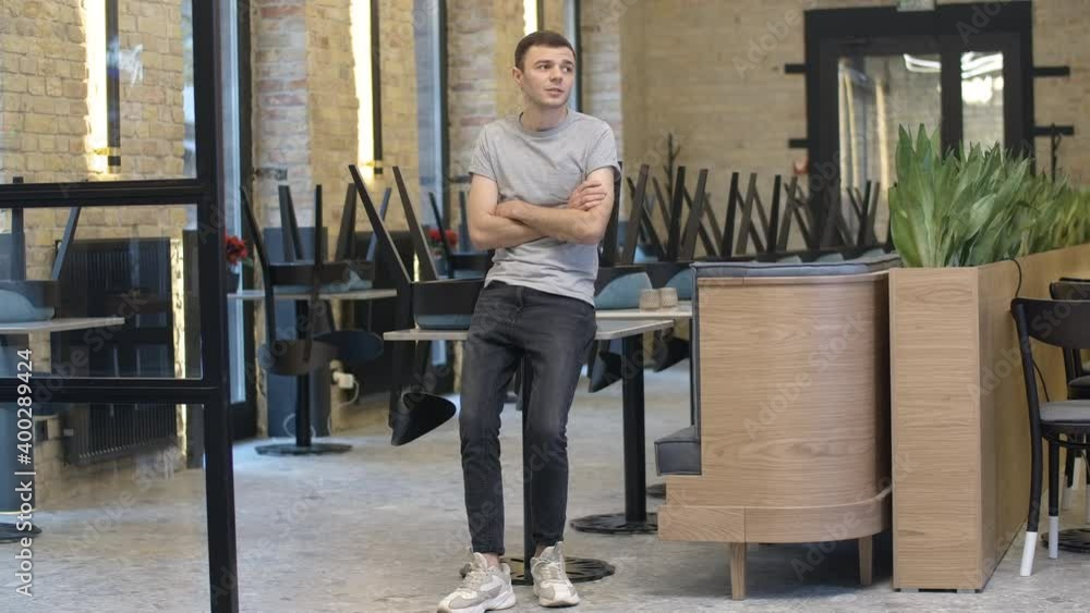 Wide shot portrait of sad young restaurant business owner sitting on ...
