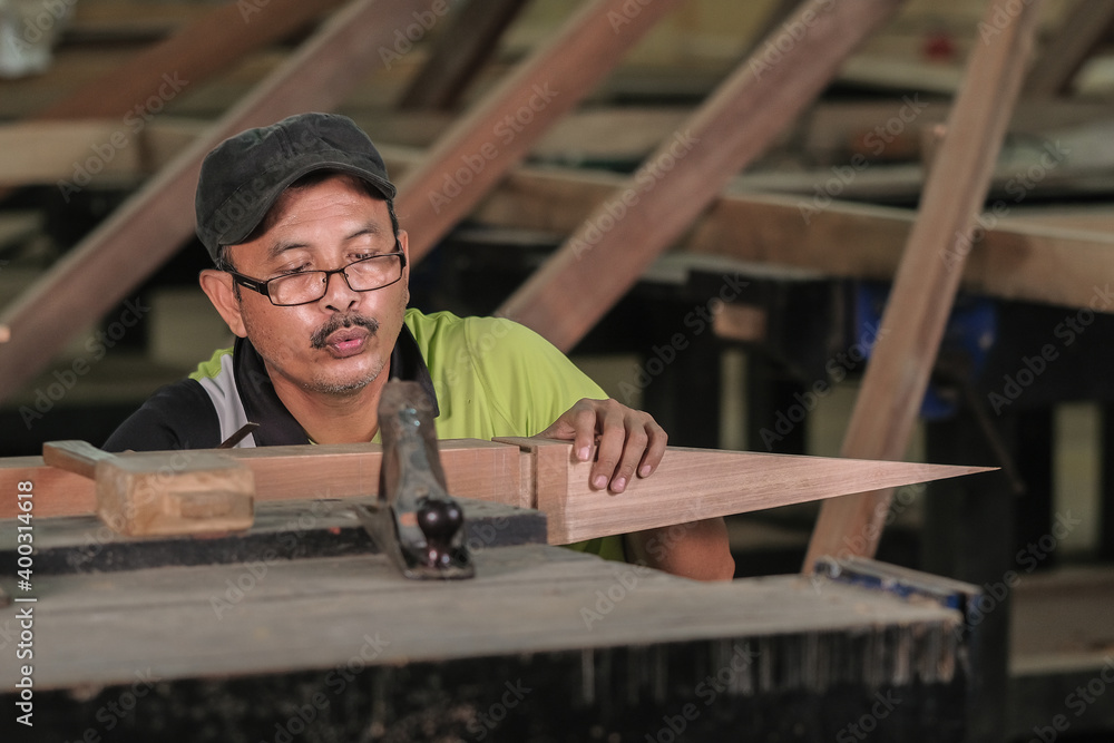Carpenter making Tunjuk Langit or one of the roof structures. Hip Roof ...