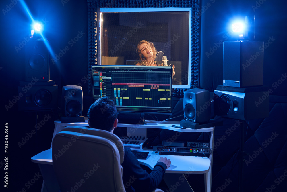 Professional male sound engineer mixing audio in recording studio ...