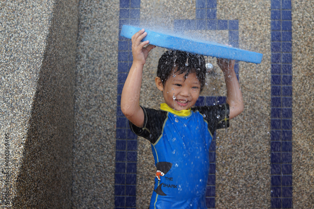 Portrait of cute little Asian boy shower outdoor before having fun in ...