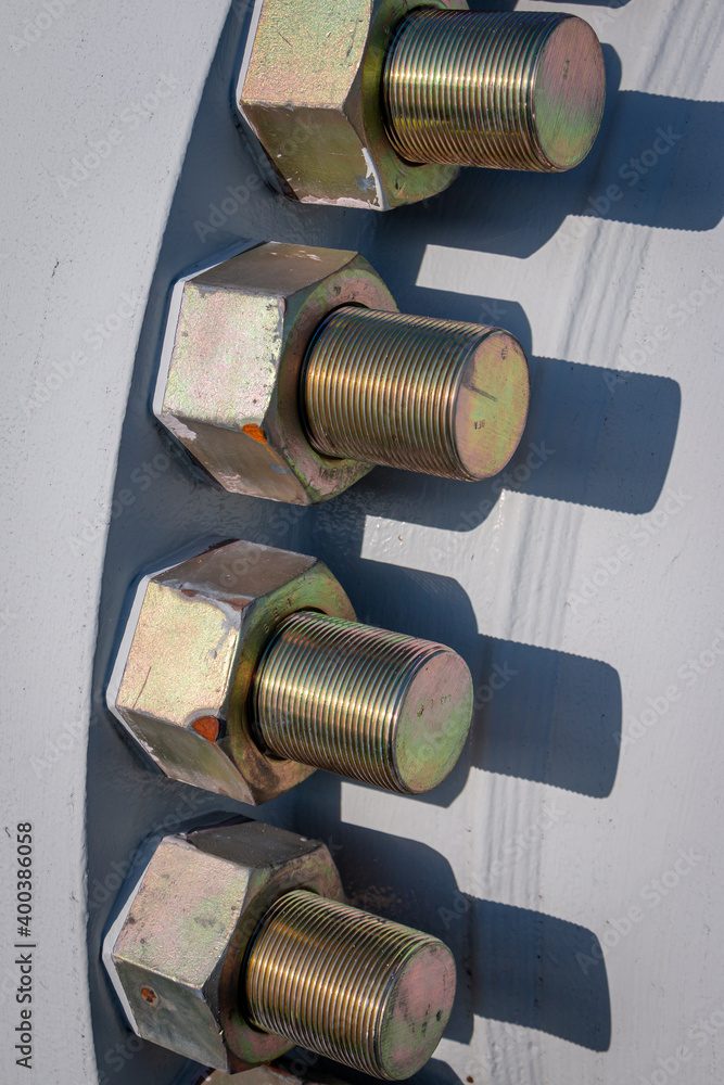 Large heavy galvanized industrial bolts and nuts mounted in a large ...