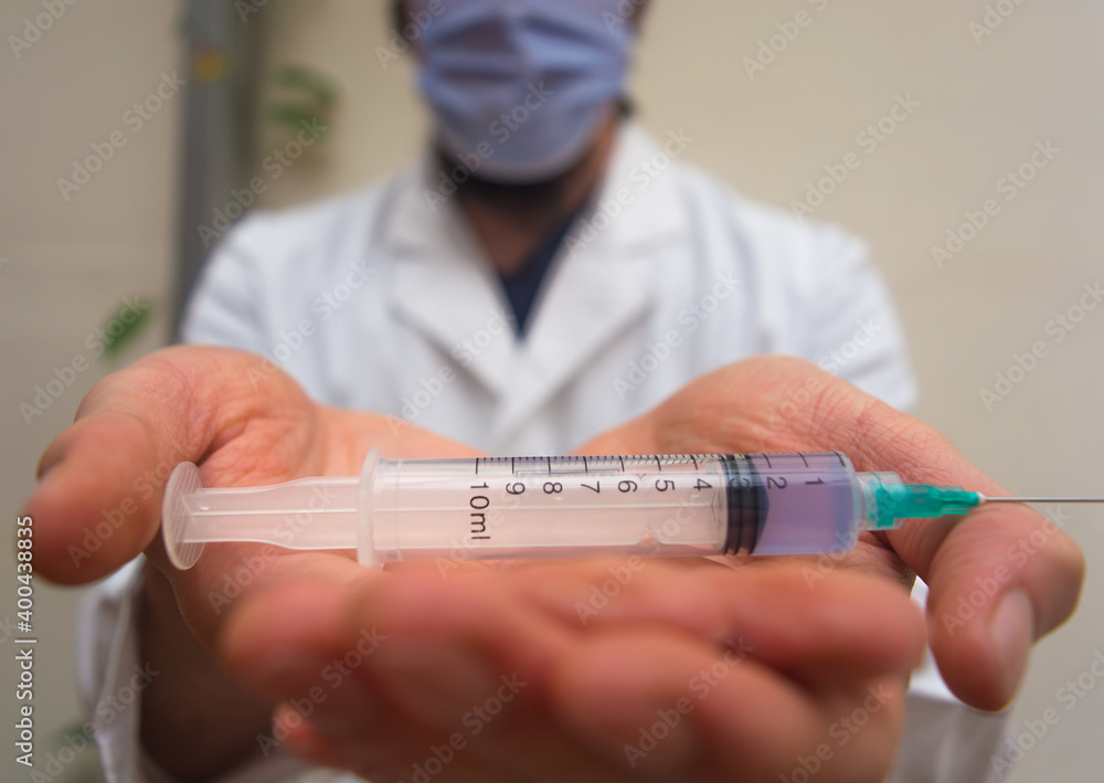 Disposable plastic syringe with blue liquid vaccine inside and two ...