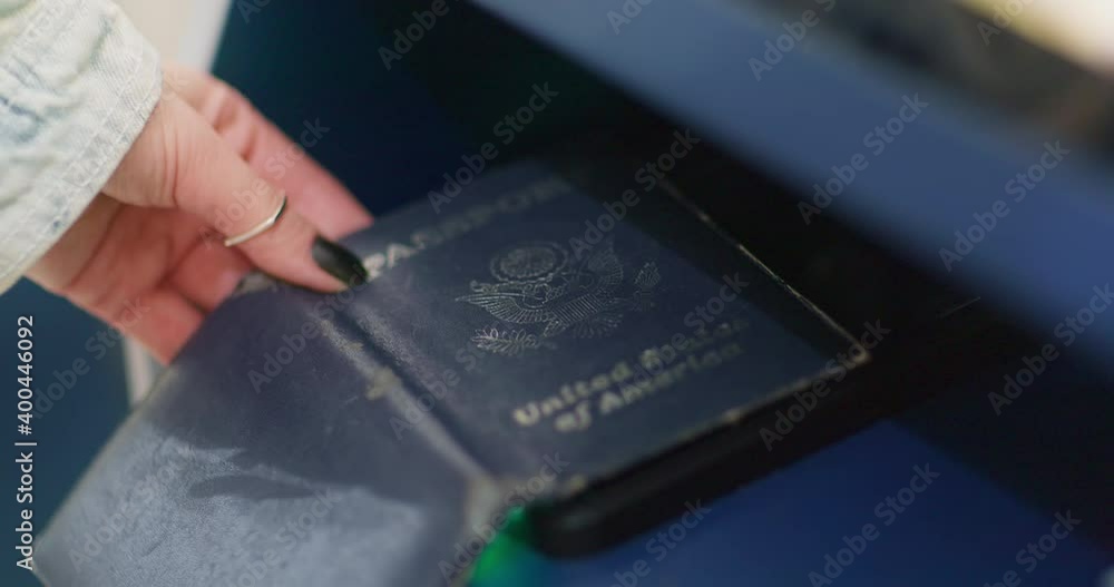 Closeup of woman hand scanning the open passport of United States of ...
