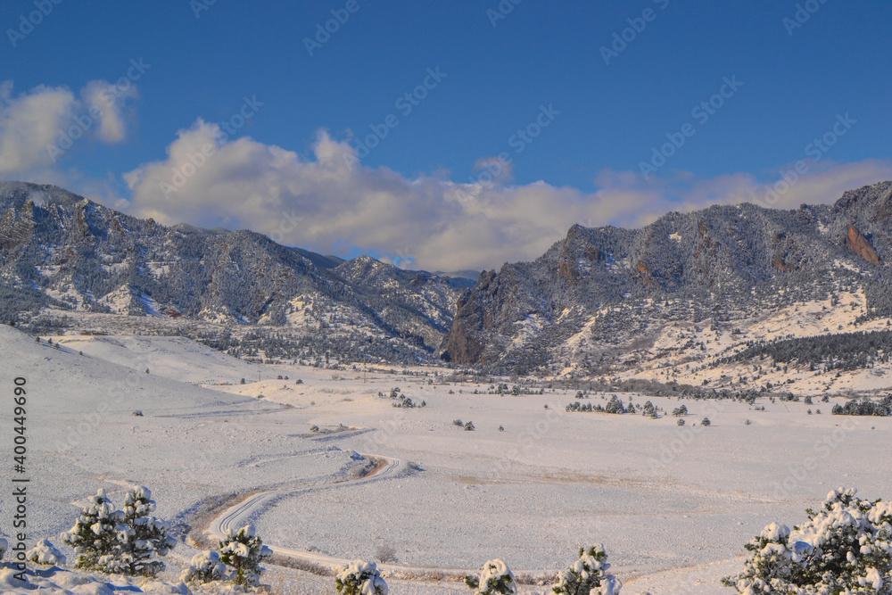 Snow capped Boulder Flat Irons mountain valley with a winding road in ...