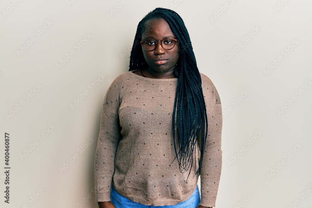 Young black woman with braids wearing casual clothes and glasses ...