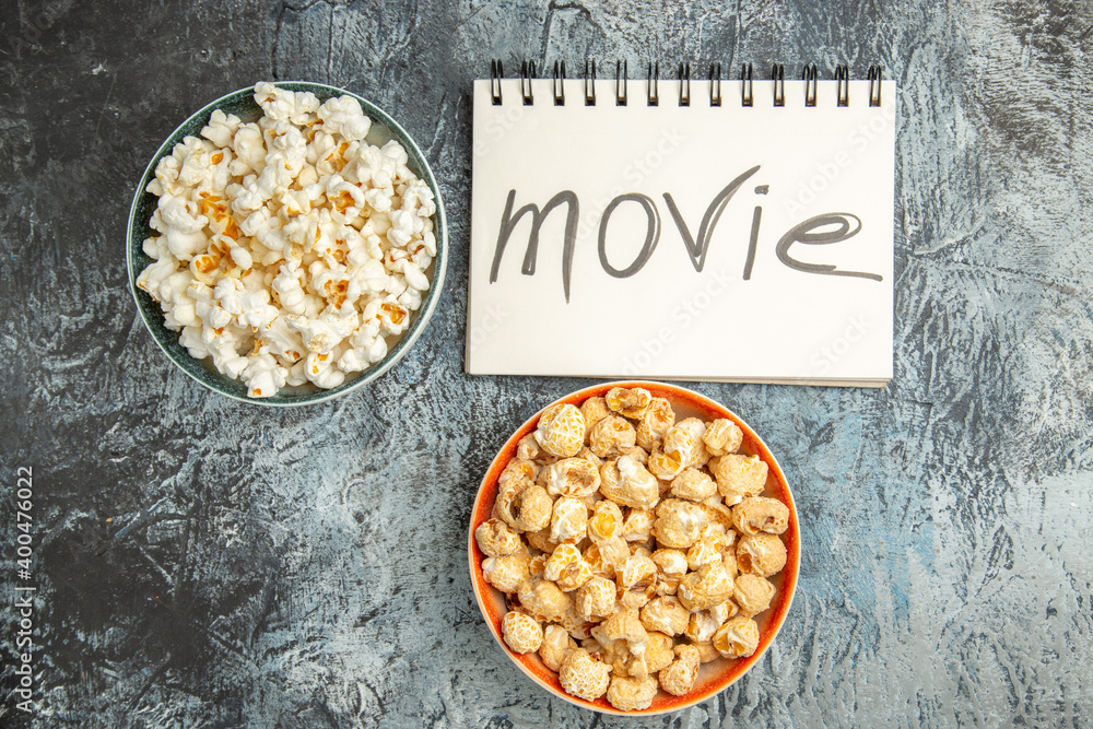 top view fresh popcorn with movie written notepad on a light background ...
