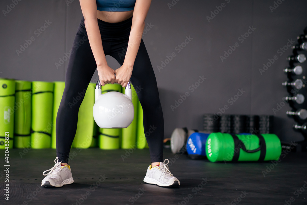 Powerful sportive people lifting up a heavy kettle ball in a gym, body ...