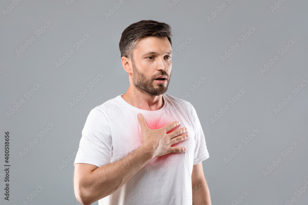 Man with chest pain touching inflammated zone, grey background Stock ...