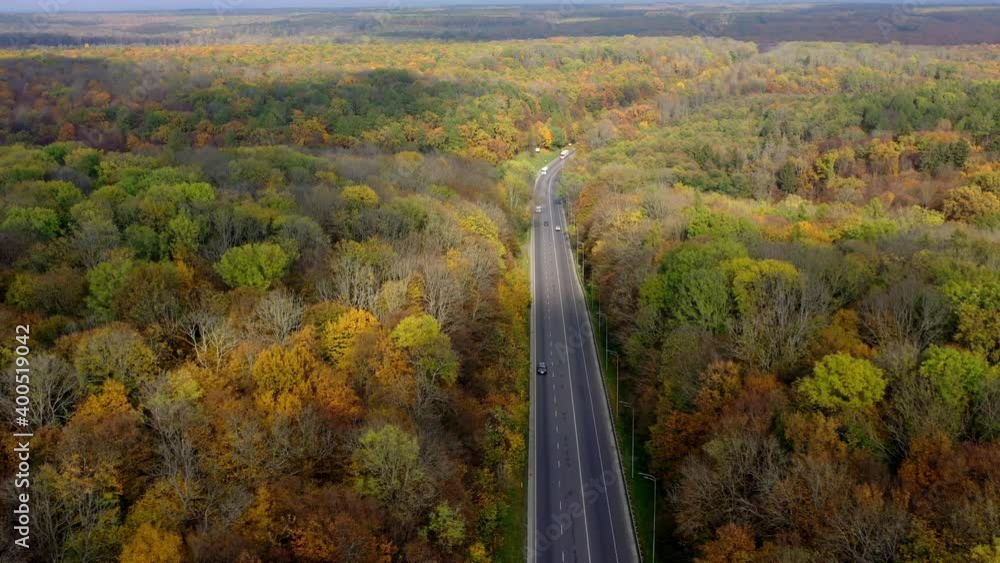 Autumn scenery and a highway. Panoramic view of a road with cars moving ...