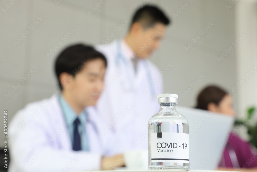 Covid-19 vaccine with group of doctors brainstorming as teamwork ...